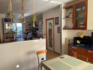 Cozinha moderna com área de jantar, armários de madeira e vista para o exterior.