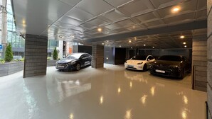 Um estacionamento interno moderno com três carros estacionados.