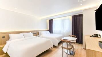 Quarto de hotel com duas camas, uma escrivaninha e uma cadeira.