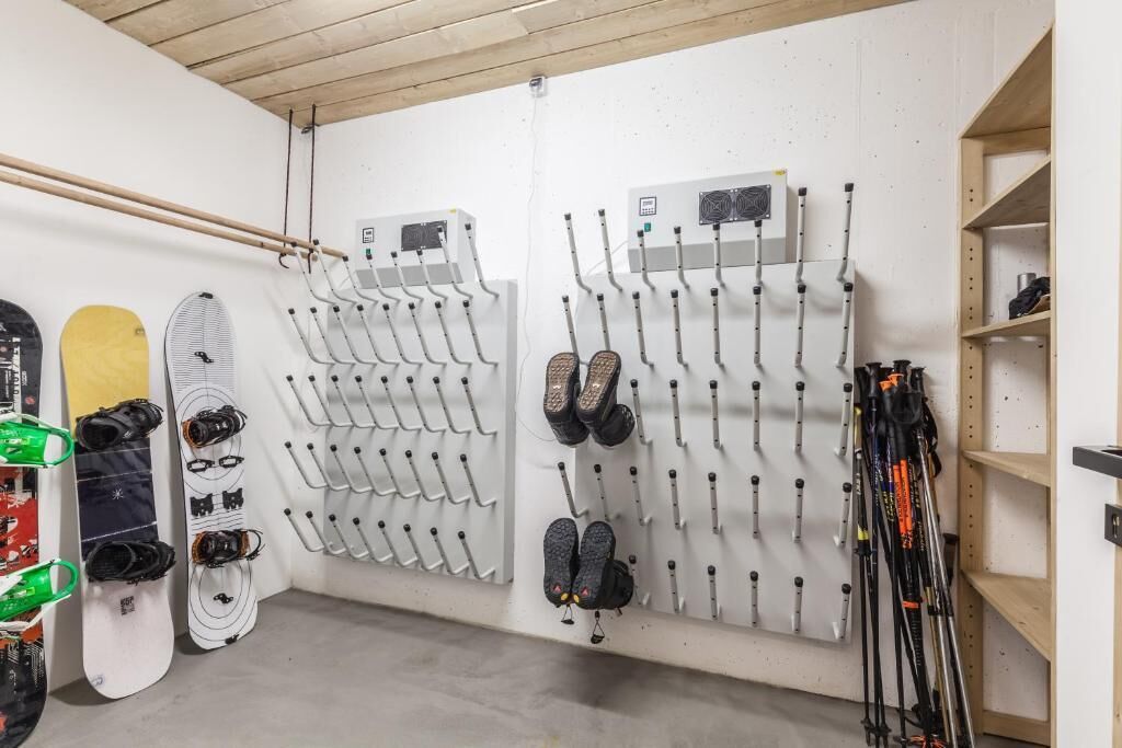 Uma área de armazenamento com pranchas de snowboard e bastões de esqui organizados em suportes.