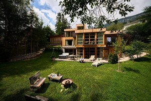 Uma casa moderna com um amplo quintal, área de estar externa e lareira.