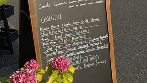 Quadro-negro com menu listando pratos e bebidas.