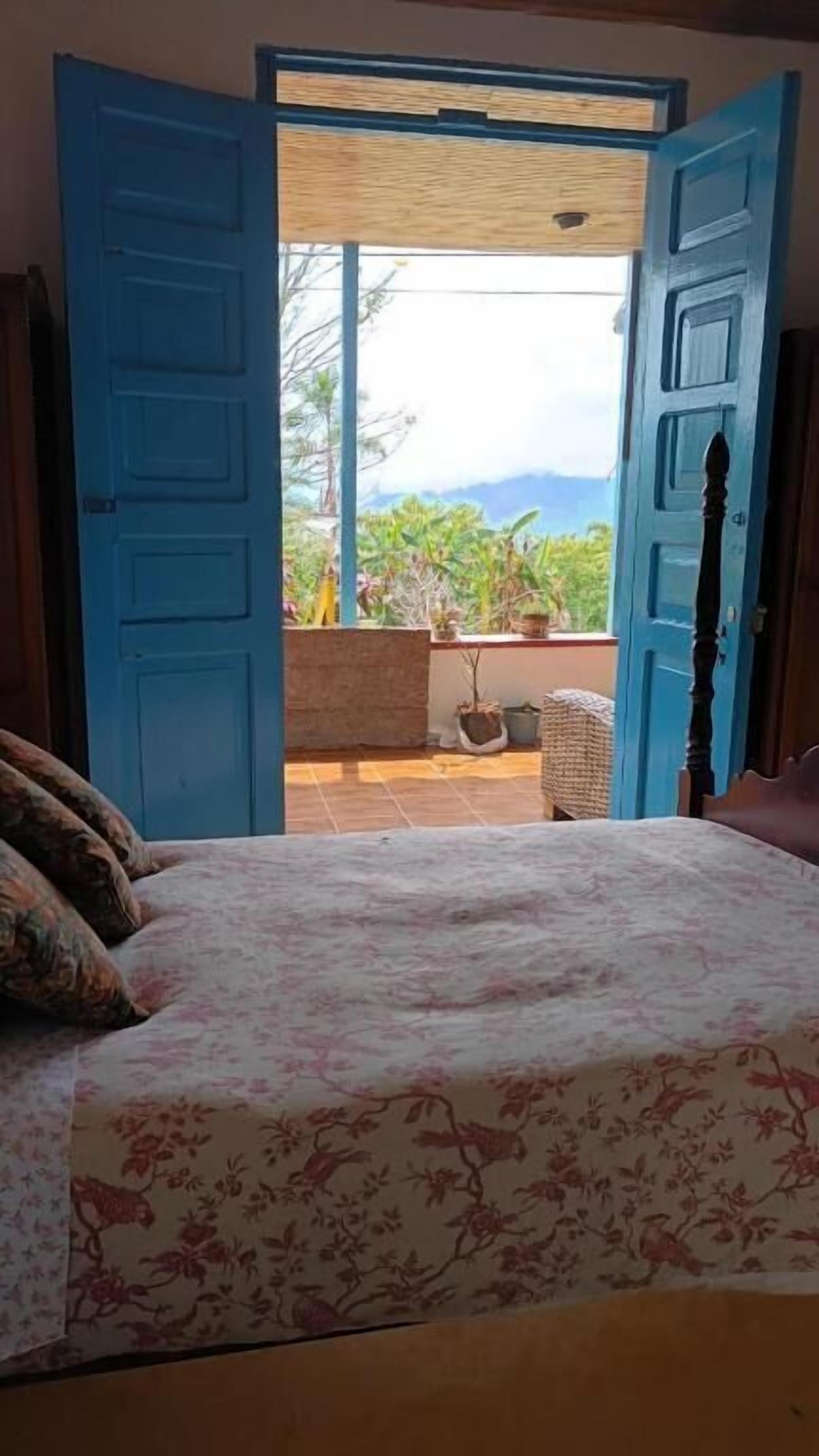 Quarto com cama, janela e vista para o exterior.