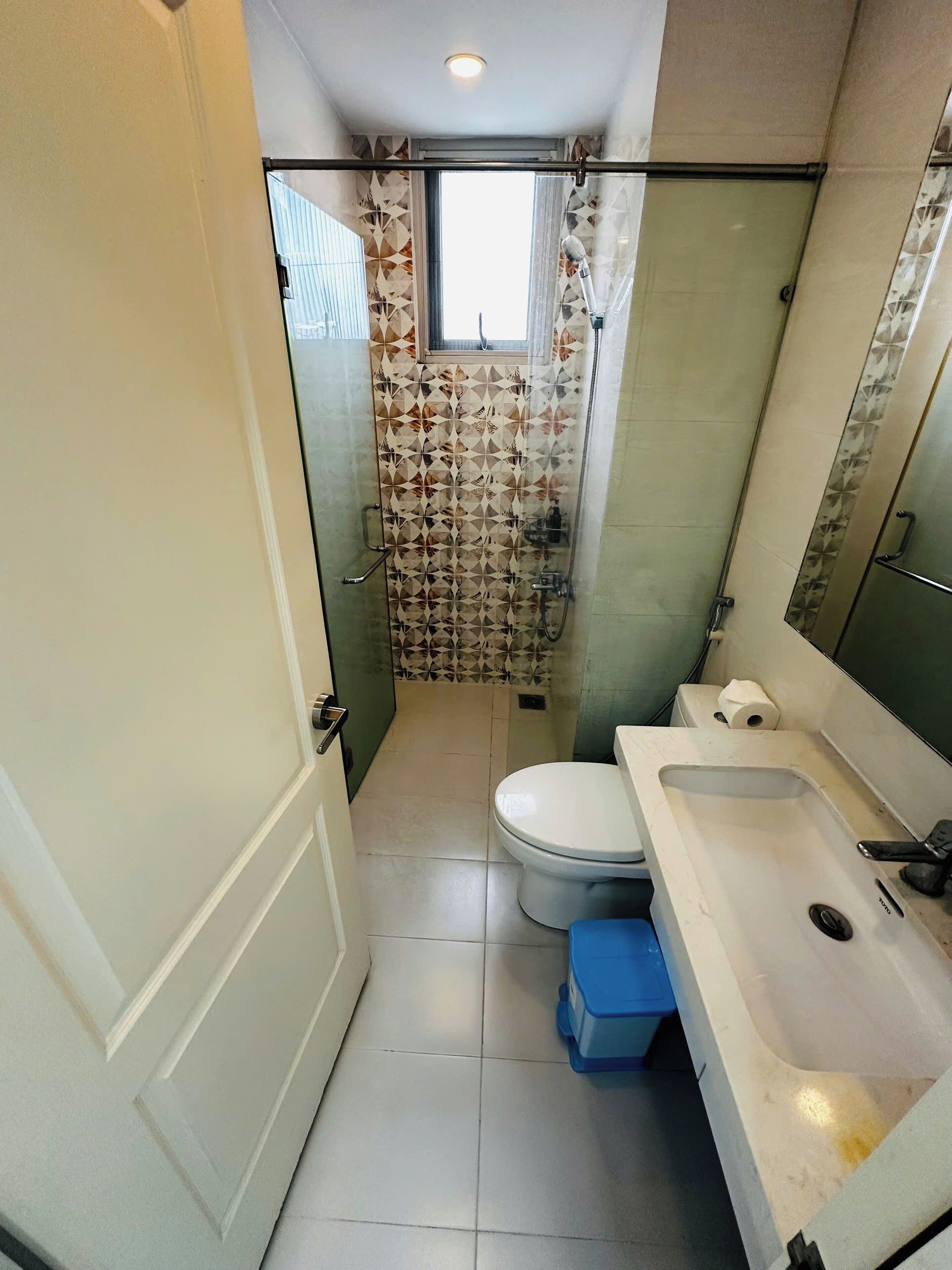 Uma casa de banho com sanita, lavatório e área de duche.