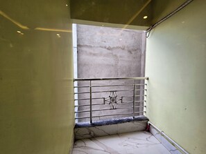 Uma escada com corrimão de metal, parede de concreto e piso de mármore.