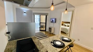 Cozinha moderna com bancadas de granito, fogão embutido e área de jantar com banquetas.