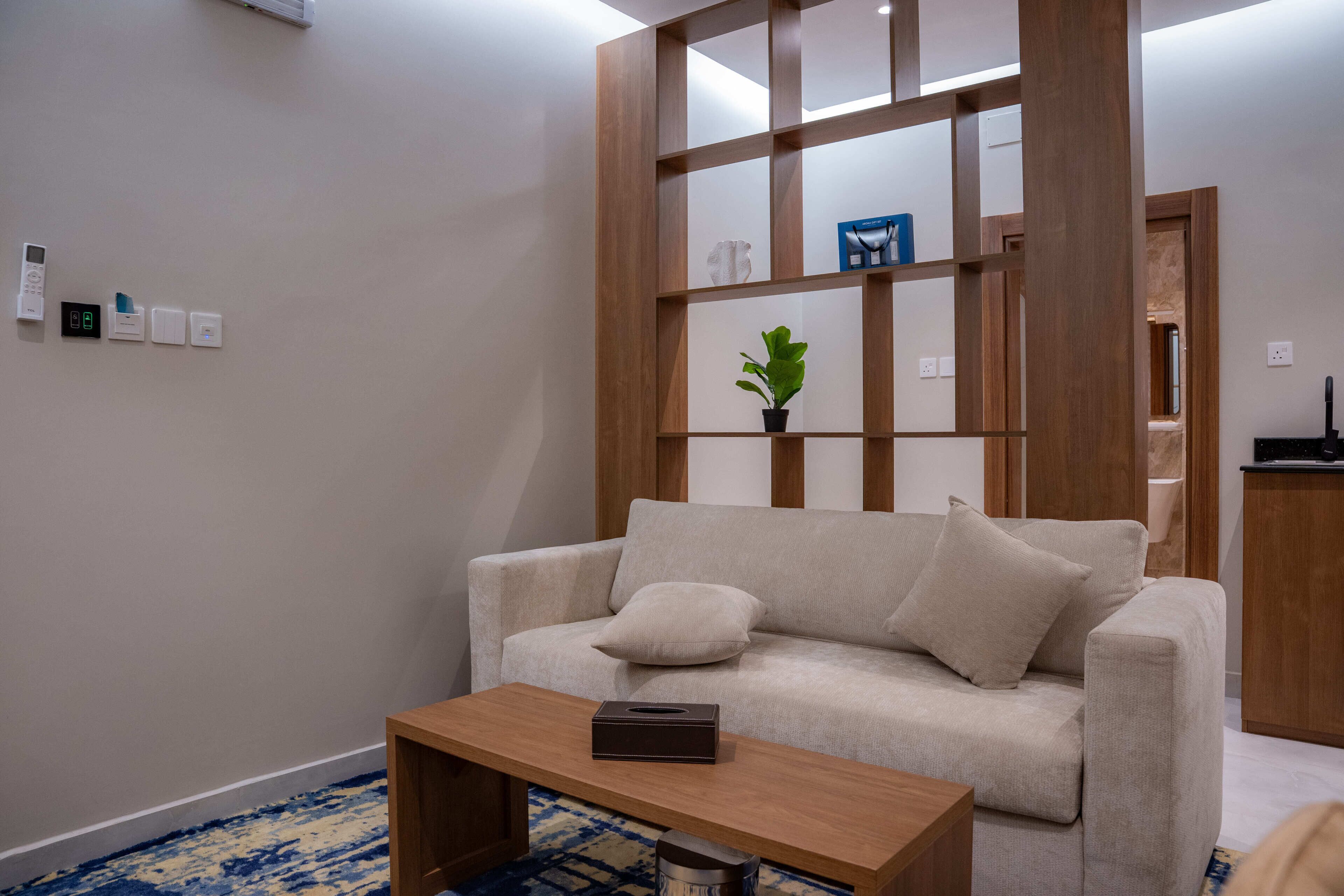 Uma sala de estar moderna com um sofá, uma mesa de centro e uma planta decorativa.
