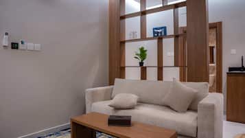 Uma sala de estar moderna com um sofá, uma mesa de centro e uma planta decorativa.