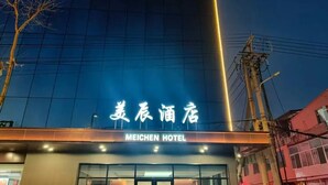 Exterior do Hotel Meichen com fachada moderna e sinalização iluminada.