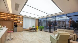 Um interior moderno com área de refeições, assentos e uma grande janela de vidro.
