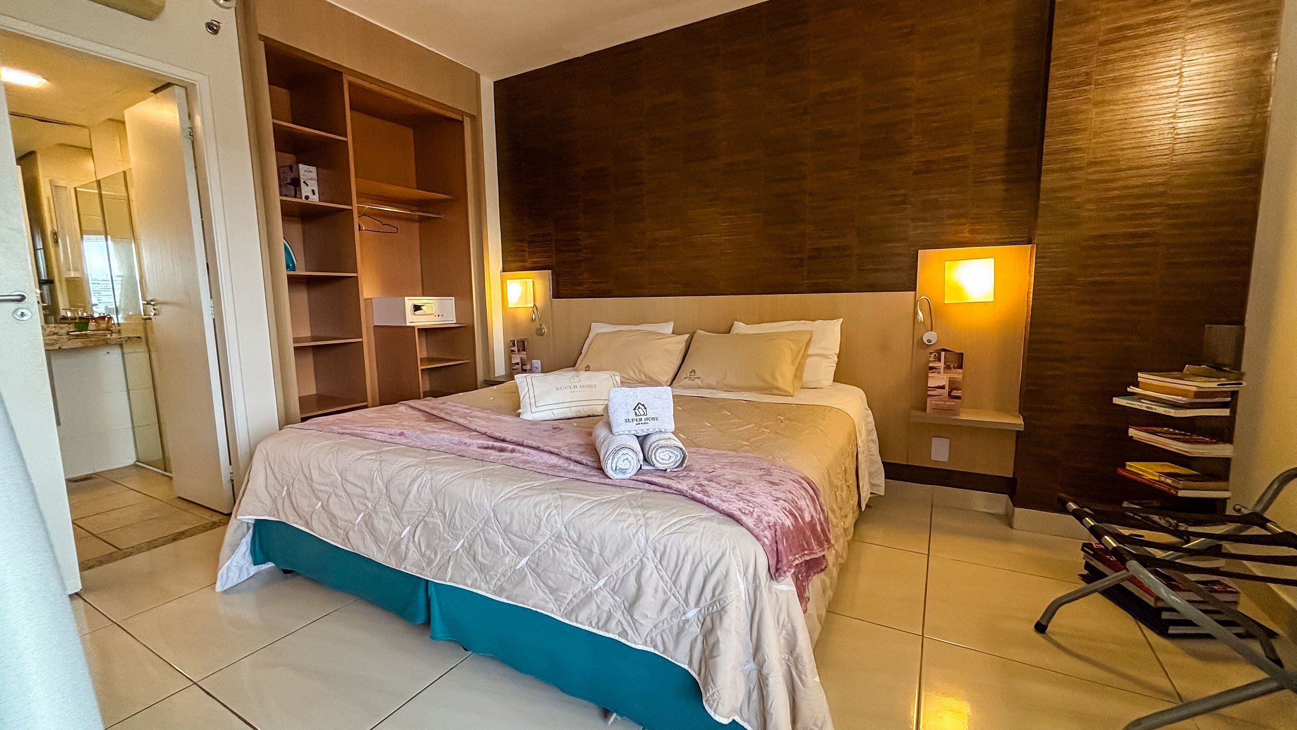 Quarto bem organizado com cama, mesas de cabeceira e guarda-roupa.