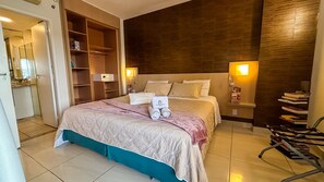 Quarto bem organizado com cama, mesas de cabeceira e guarda-roupa.