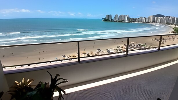 Uma varanda com vista para a praia e edifícios altos.