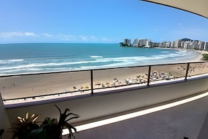 Uma varanda com vista para a praia e edifícios altos.
