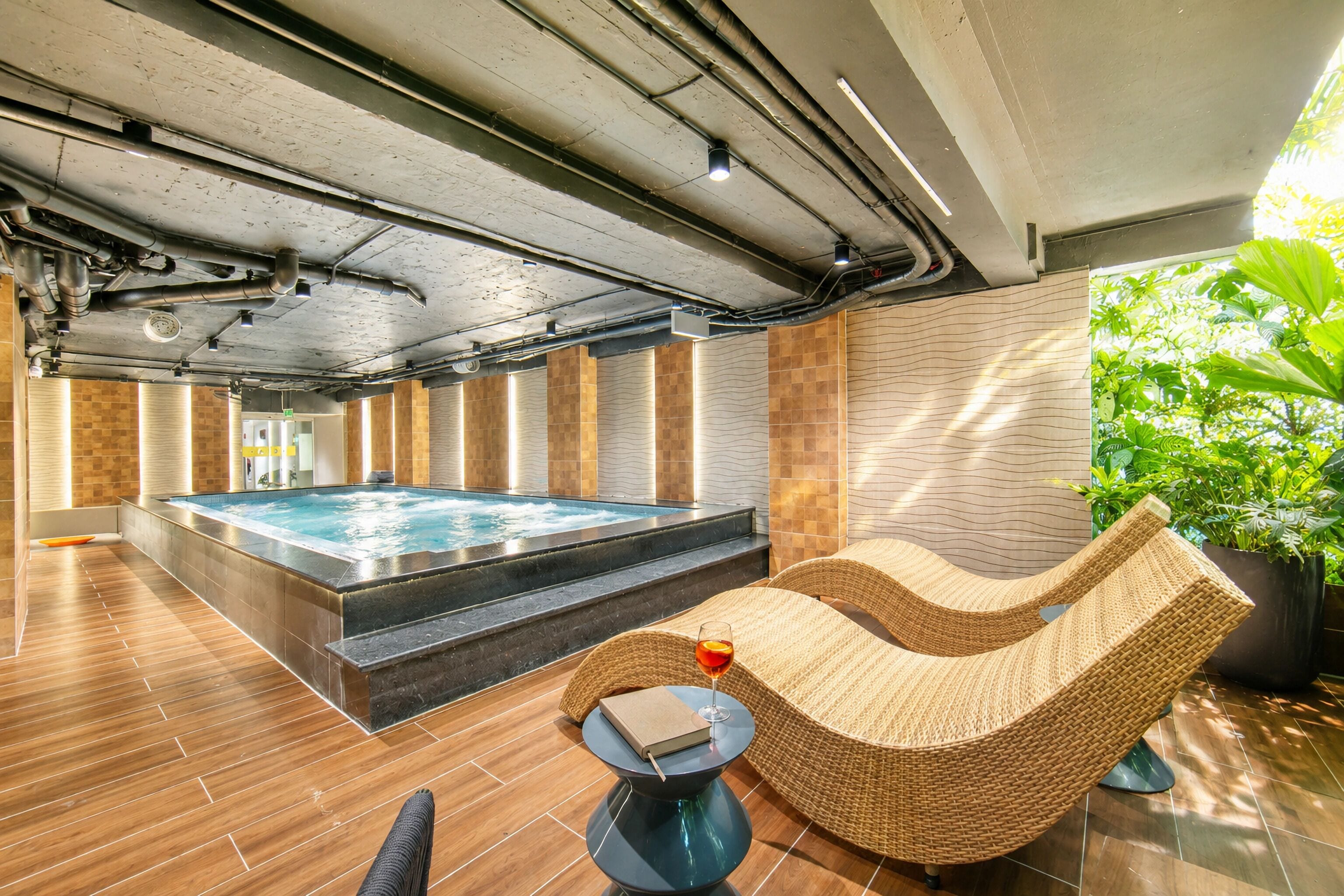 Uma área de spa com hidromassagem, piso de madeira e uma poltrona de vime.