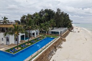 Um resort com piscina, espreguiçadeiras e praia.