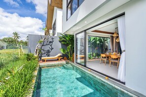 Uma casa moderna com piscina, área de estar externa e sala de jantar com vista para o verde ao redor.