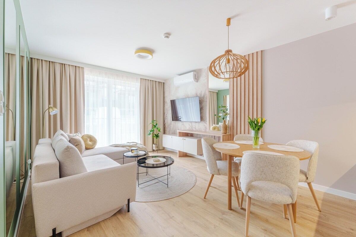 Uma sala de estar moderna com sofá, mesa de centro, mesa de jantar e cadeiras.
