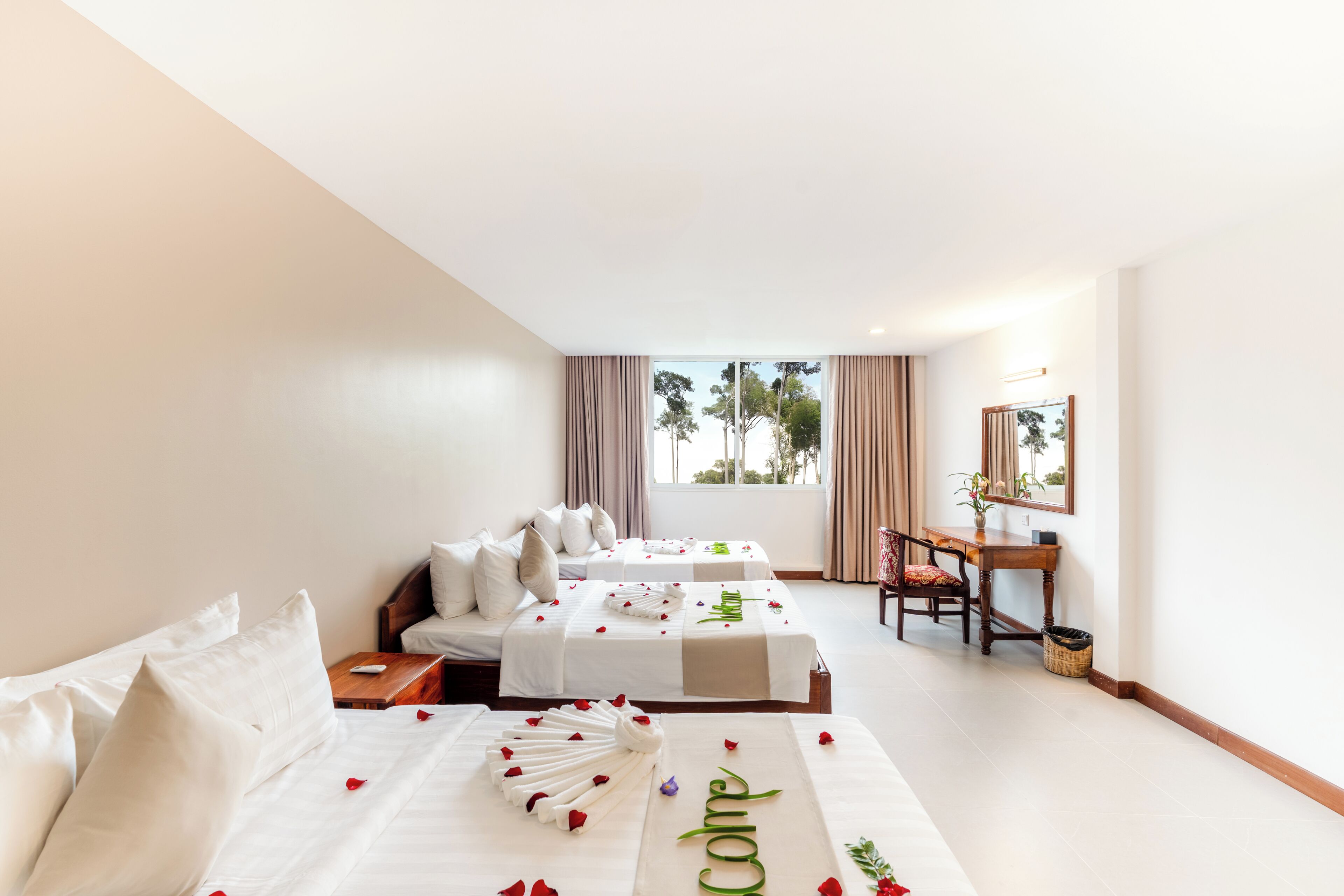 Quarto de hotel com duas camas, uma escrivaninha e uma cadeira.