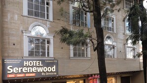Um hotel com uma placa indicando 'Serenewood' e uma loja Dolce & Gabbana.