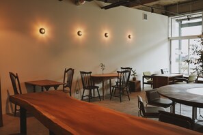 Uma sala de conferências com uma mesa comprida, várias cadeiras e uma mesa redonda.