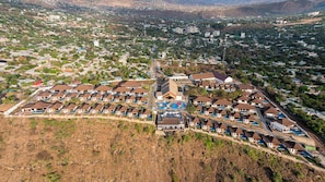 Zona residencial com várias casas e um edifício central com piscina.