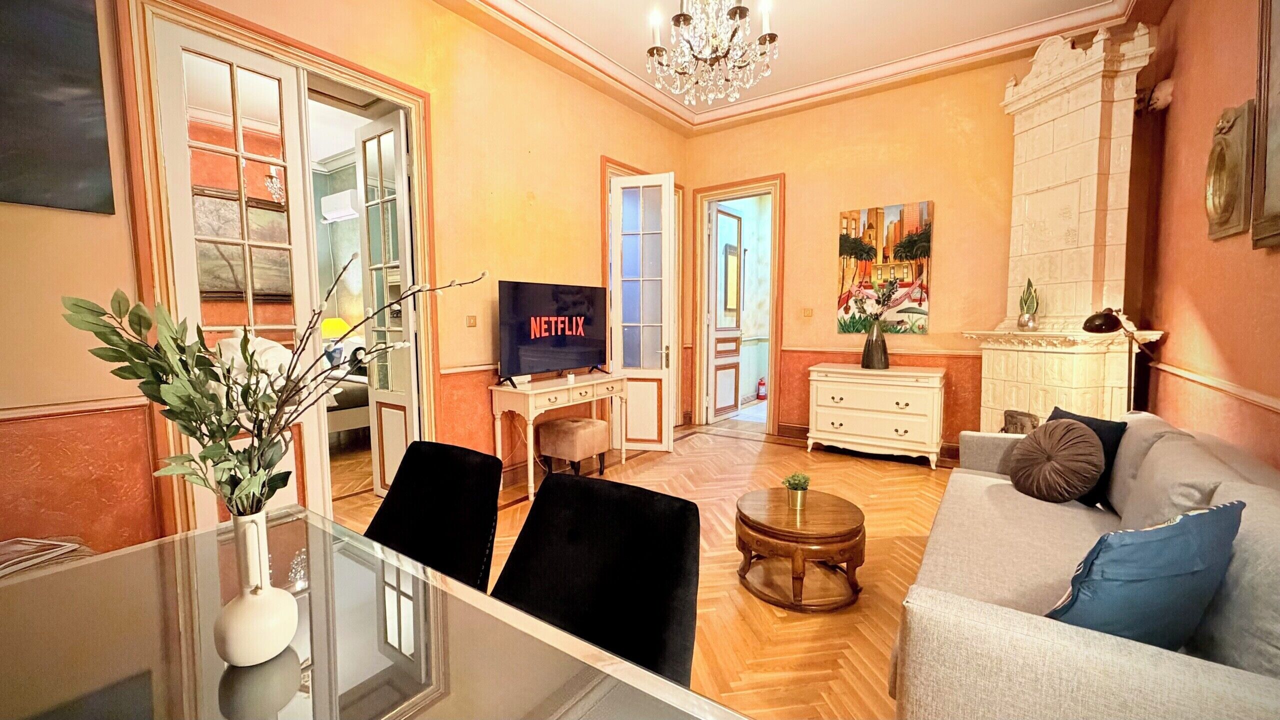 Sala de estar com televisão, sofá e área de jantar.
