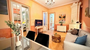 Sala de estar com televisão, sofá e área de jantar.