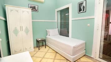 Um quarto com uma cama, um guarda-roupa, uma janela e uma porta.