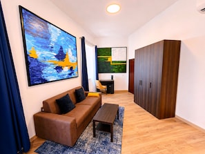 Uma sala de estar moderna com um sofá marrom, uma mesa de centro e obras de arte nas paredes.