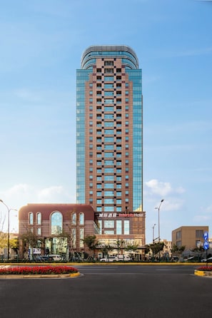 Um edifício alto de hotel com design moderno, apresentando uma fachada com combinação de vidro e tijolos, e uma sinalização chamativa para o Intercity Hotel.