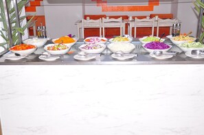 Uma mesa de buffet com diversos pratos e utensílios.