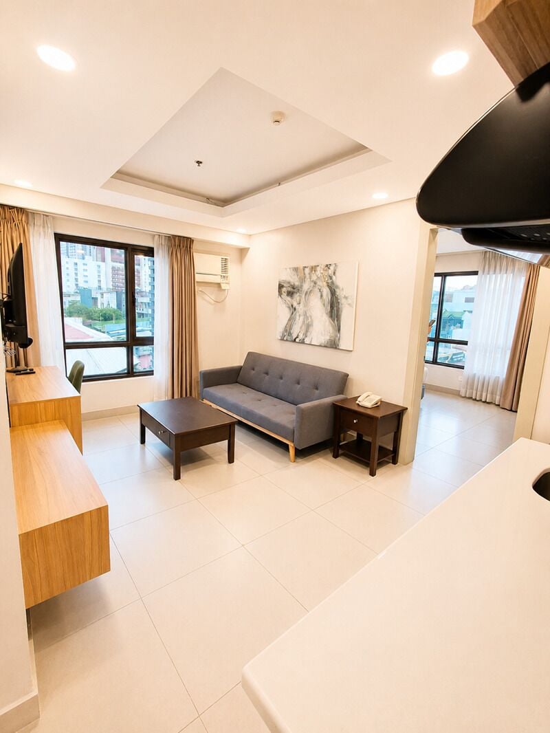 Uma sala de estar moderna com sofá, mesa de centro e televisão.