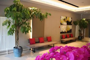 Um interior moderno com área de estar, plantas em vasos e obras de arte na parede.