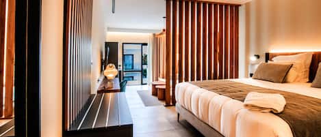 Quarto de hotel moderno com uma cama grande, uma escrivaninha e vista para o exterior.