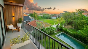 Varanda com vista para uma área residencial, piscina e jardim.