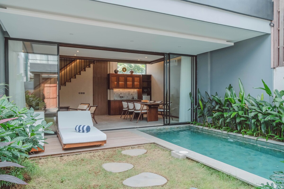 Uma casa moderna com piscina, área de refeições e cozinha.