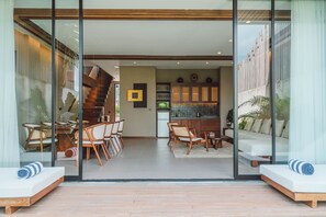 Espaço interior moderno com área de refeições, cozinha e espaço para sentar.