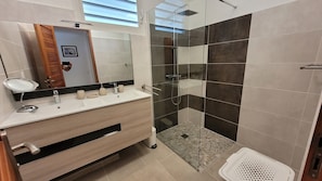 Casa de banho moderna com toucador, espelho e zona de duche.