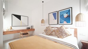 Quarto moderno com cama, escrivaninha, cadeira e duas luminárias pendentes fixadas na parede.
