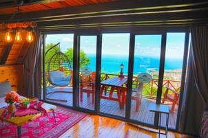 Quarto com uma grande porta de vidro deslizante que dá para um deck externo com vista para o oceano.