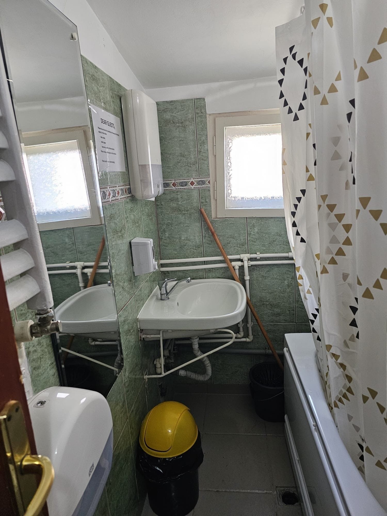 Casa de banho compacta com lavatório, espelho e janela.
