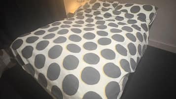 Uma cama com colcha de bolinhas.