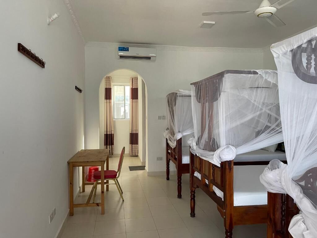 Um quarto com uma cama de madeira, uma escrivaninha e uma cadeira.