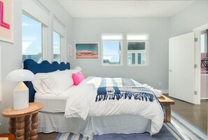 Quarto com uma cama, mesa de cabeceira, luminária e janela.