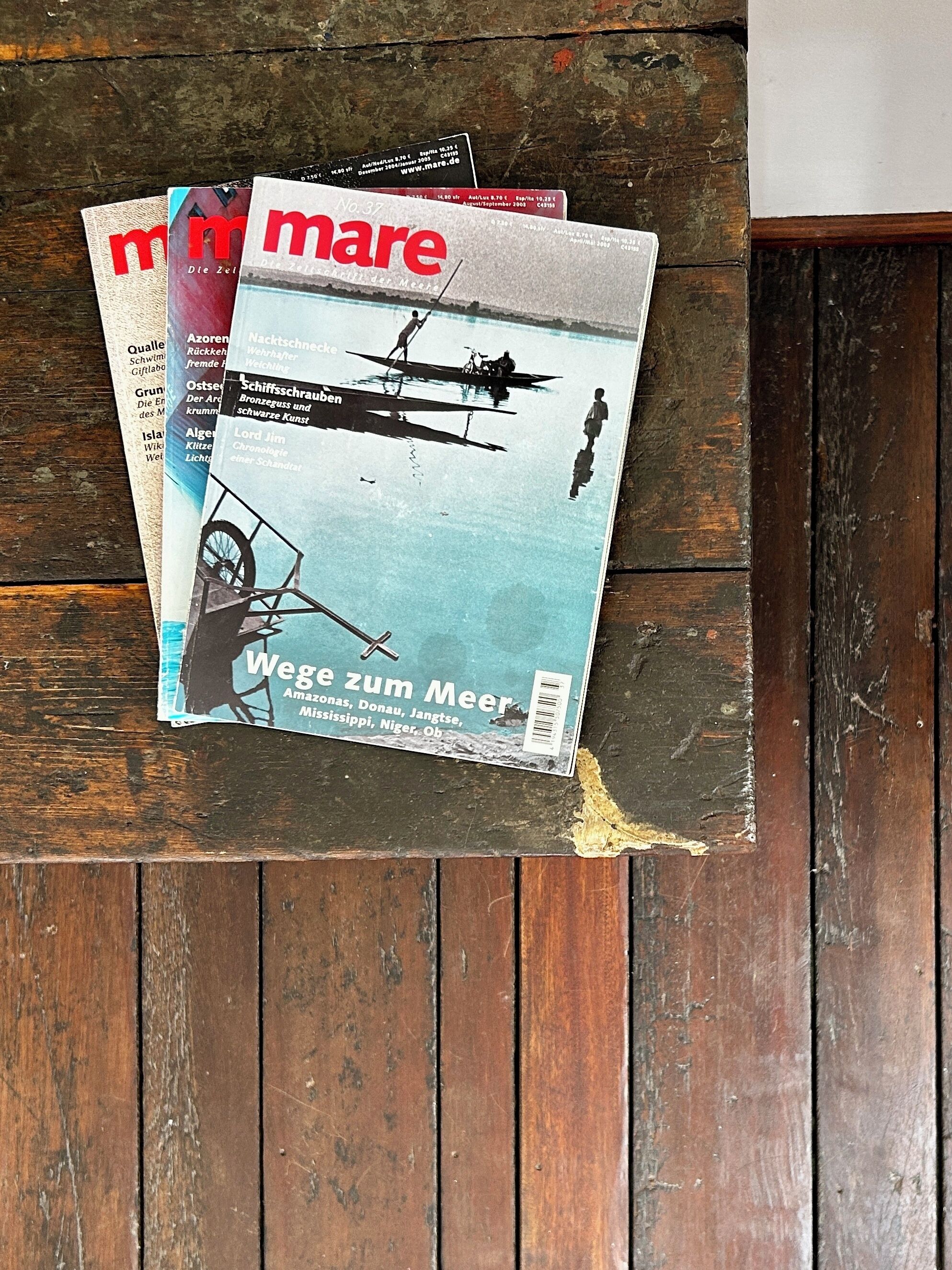 Uma pilha de revistas sobre uma superfície de madeira.