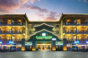 Um hotel de vários andares com arquitetura tradicional, com varandas e uma entrada central.
