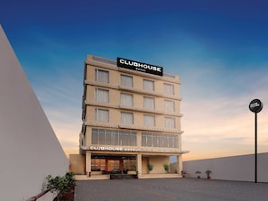 Um hotel de vários andares chamado Clubhouse Hotel, com fachada moderna, janelas amplas e telhado plano.