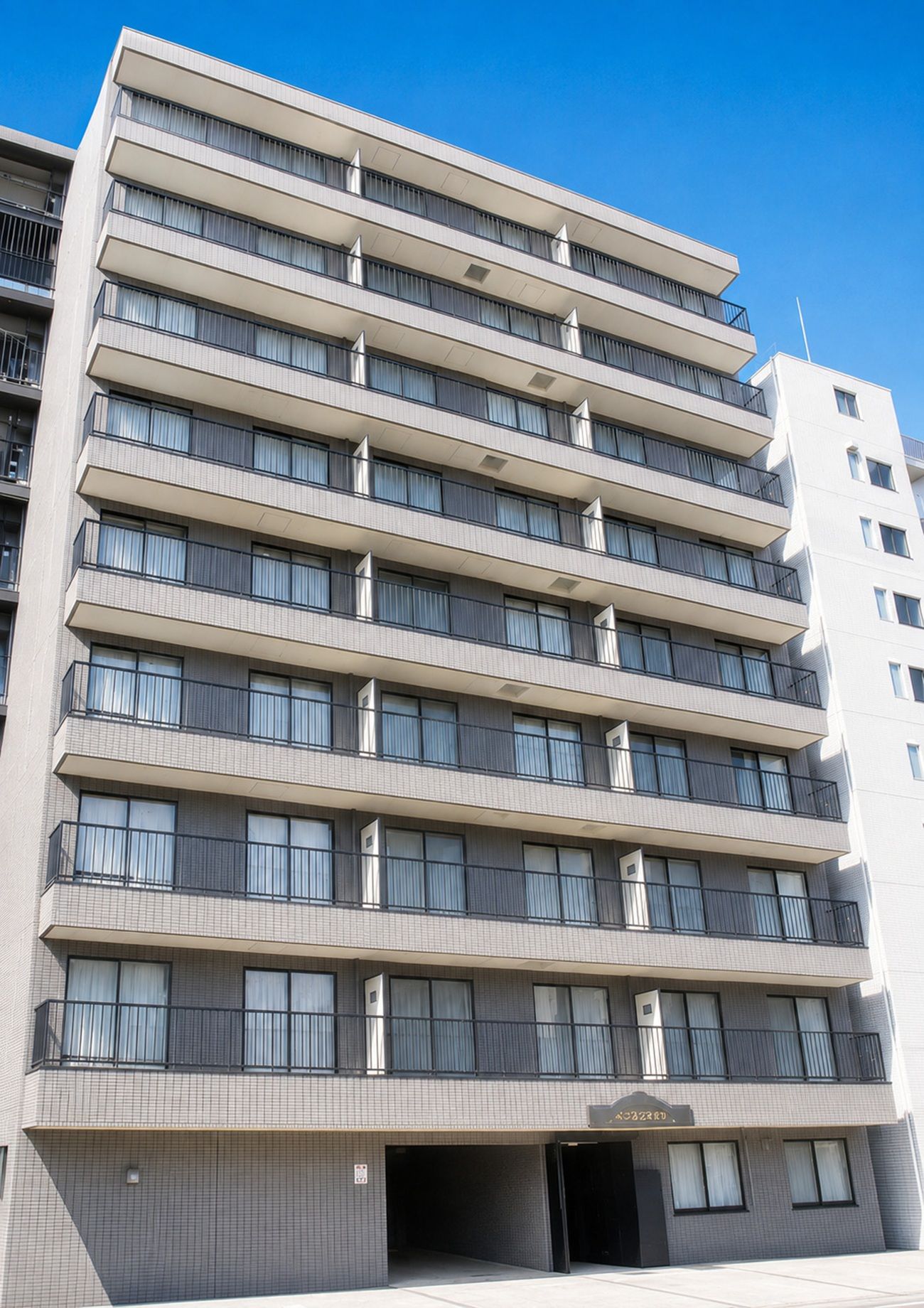Um edifício de hotel com vários andares, fachada uniforme, muitas janelas e varandas.
