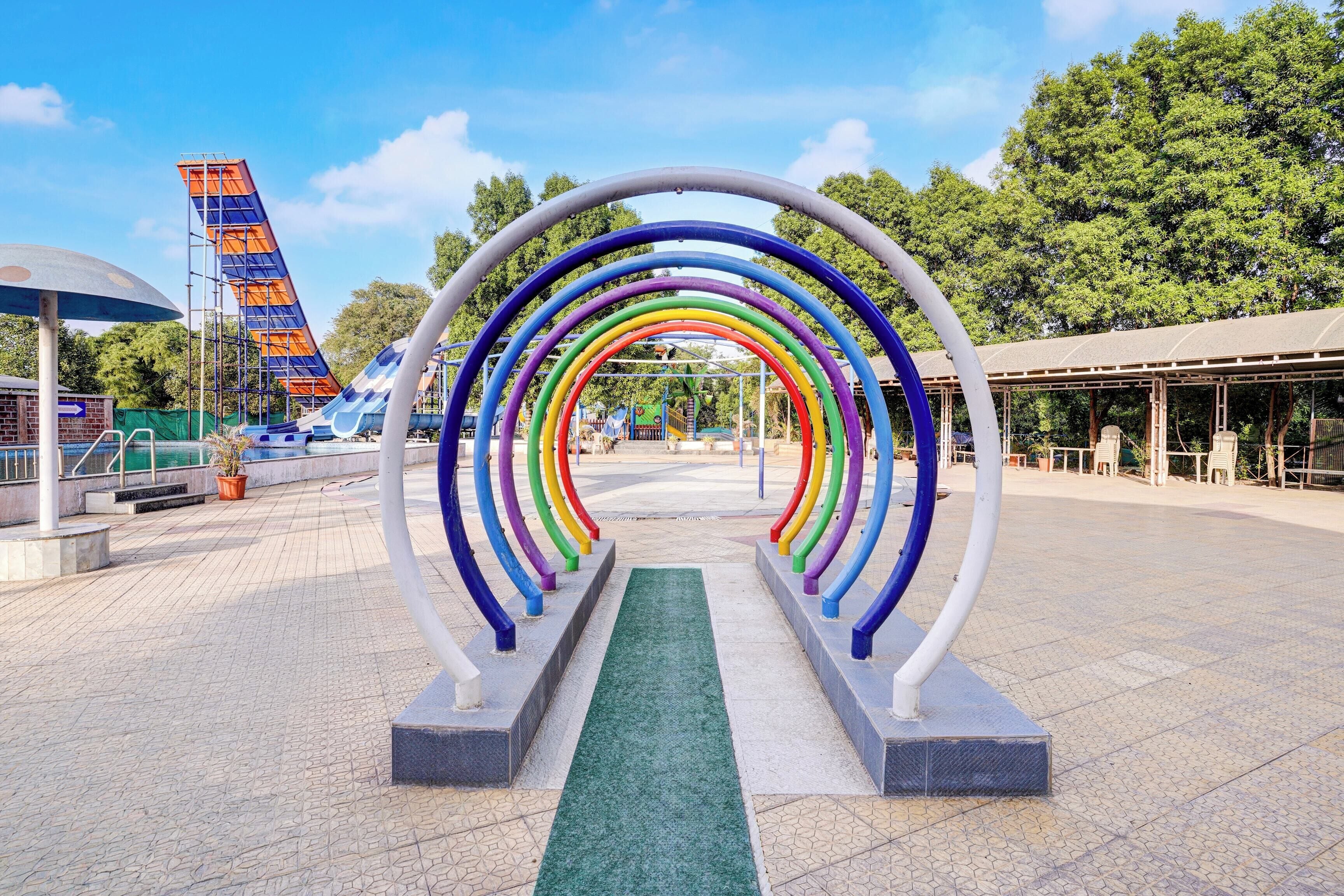 Uma estrutura de arco colorido com um caminho verde que o atravessa.